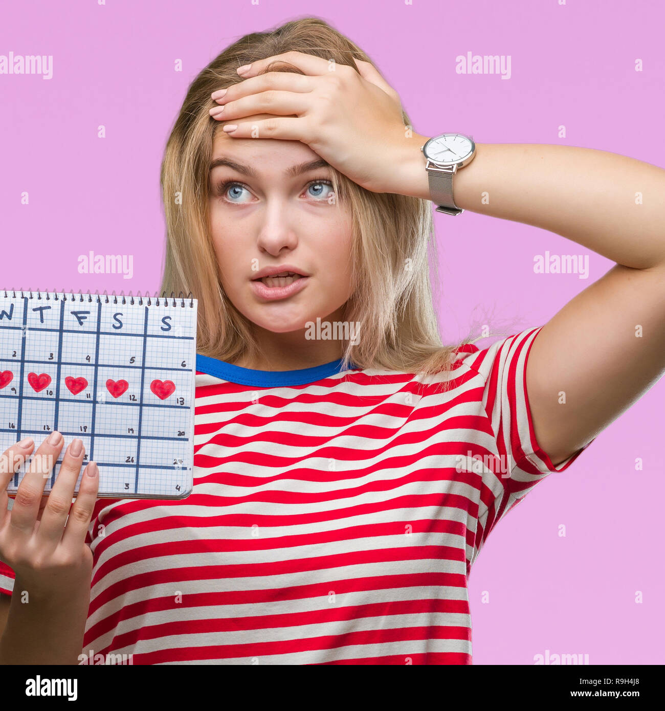 Young caucasian woman holding menstruation calendar over isolated ...