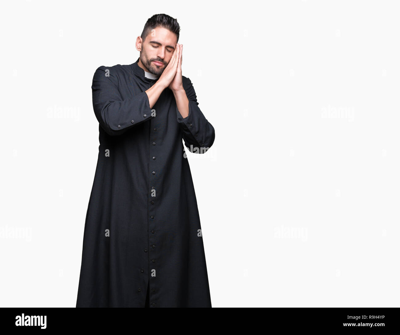 Young Christian priest over isolated background sleeping tired dreaming ...