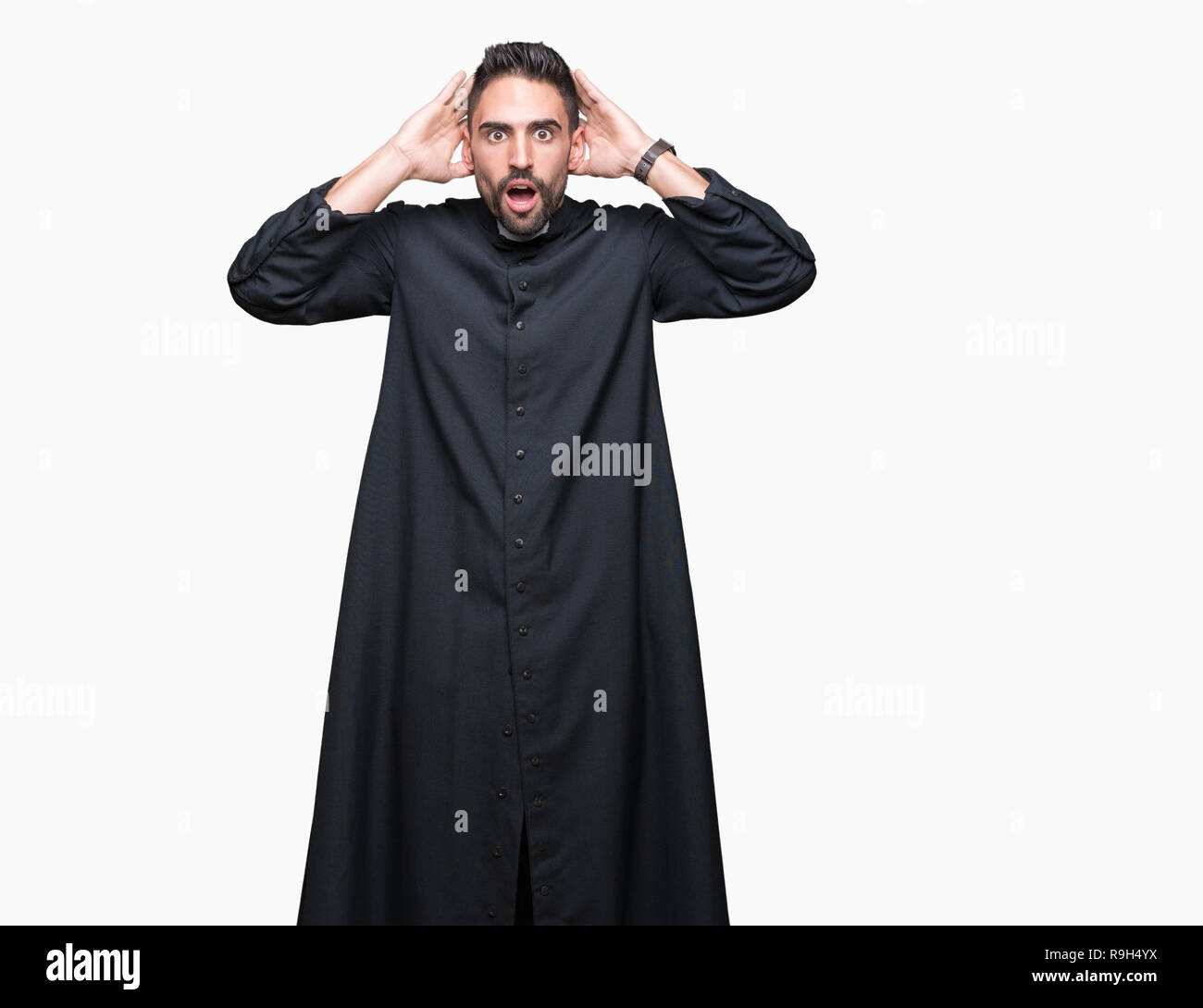 Young Christian priest over isolated background Crazy and scared with ...