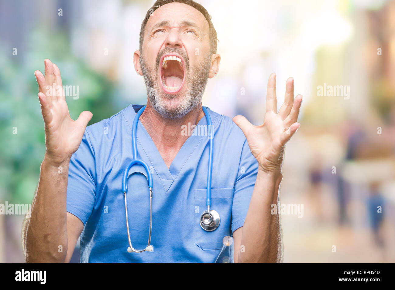 Middle age hoary senior doctor man wearing medical uniform over ...
