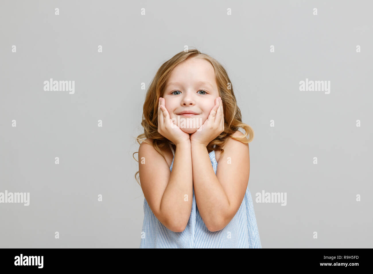 Portrait of a cute little blonde child girl on a gray background Stock ...