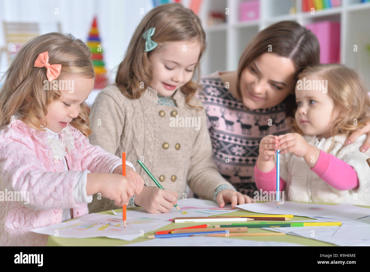 Mother and her three daughters drawing together Stock Photo - Alamy