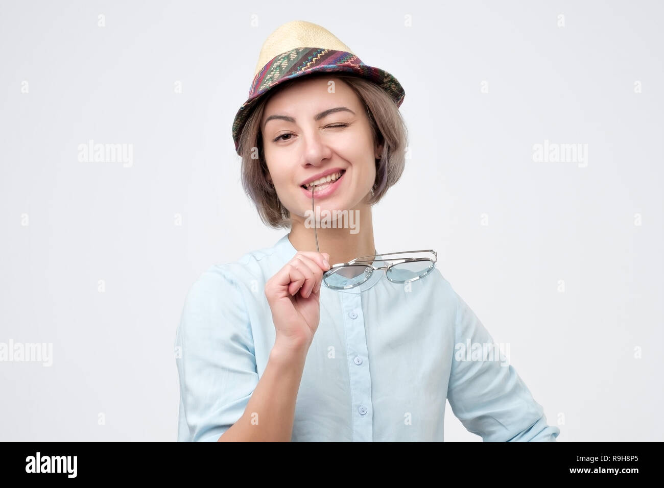 European woman, biting rim of glasses, being intrigued and interested ...