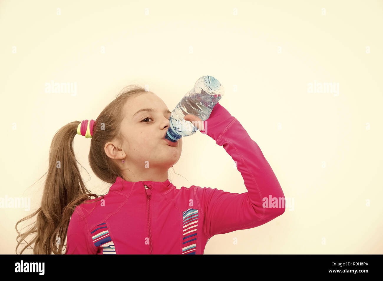 Fluid balance, hydration. Child feel thirsty in pink suit isolated on ...