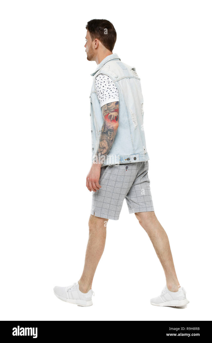 Back view of going handsome man in a shorts. walking young guy . Rear ...