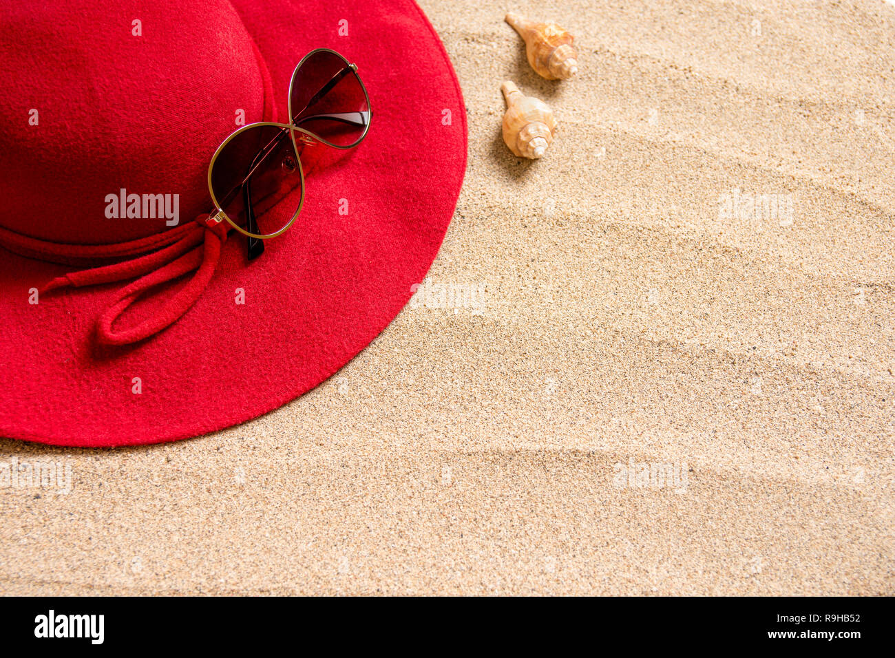 red hat on sandy beach with sunglasses, seashells and copy space for ...