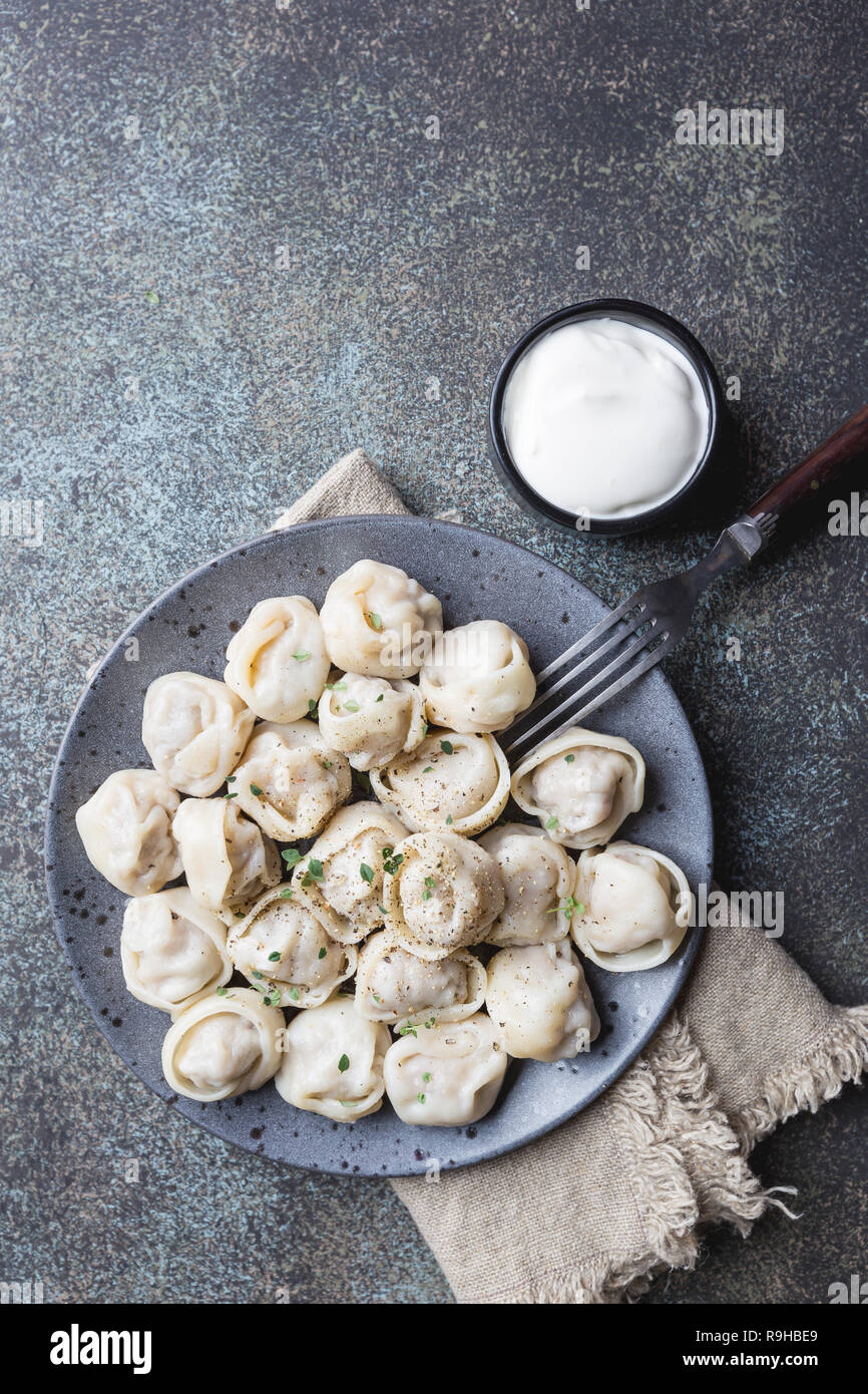 Traditional homemade Russian pelmeni meat dumplings with sour cream and ...