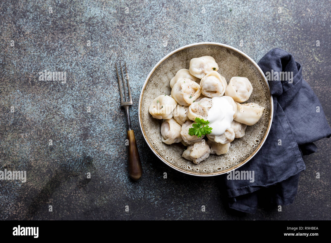 Traditional homemade Russian pelmeni meat dumplings with sour cream and ...