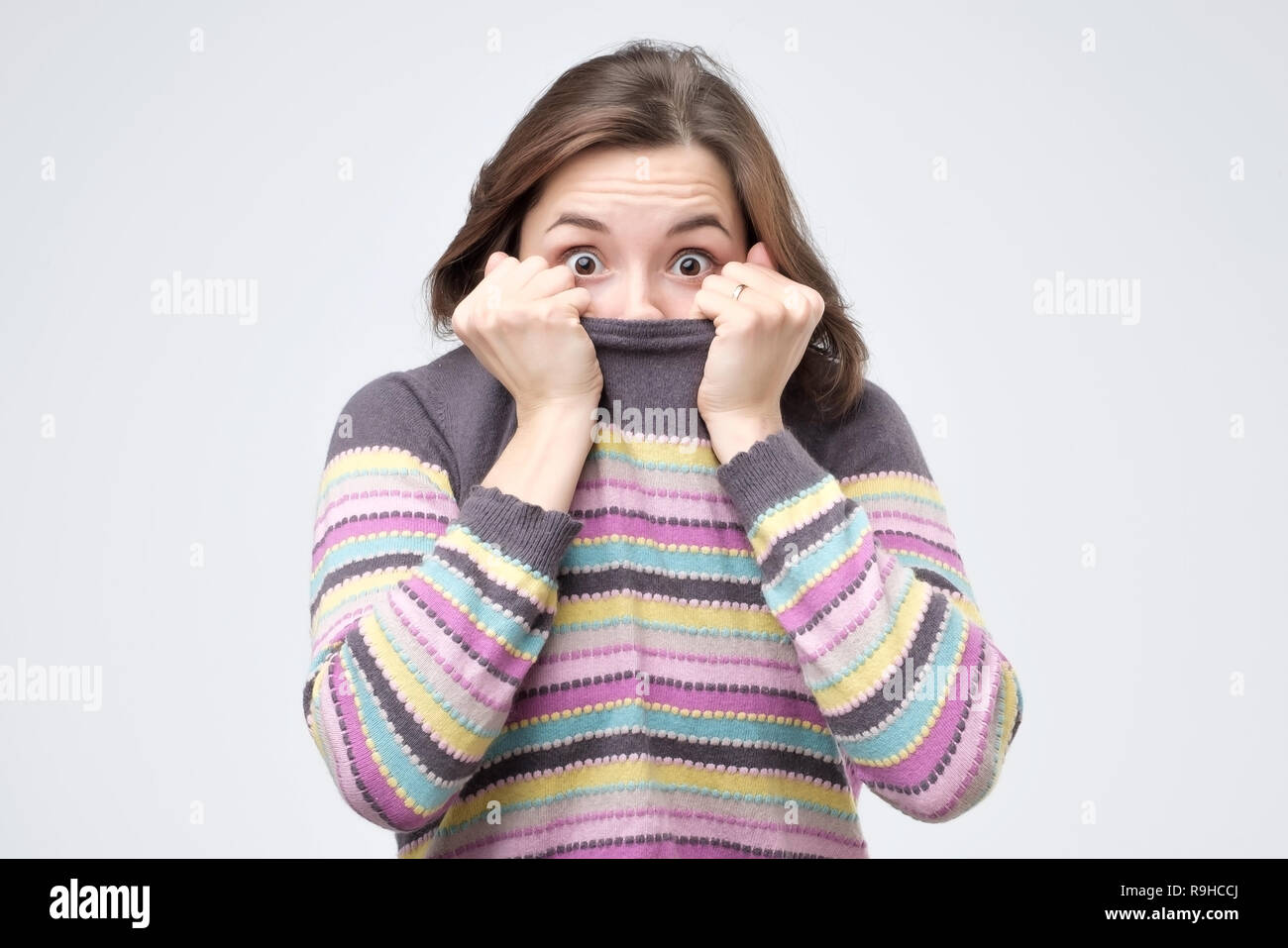 Girl pulling her trendy sweater over head having fun being childish ...