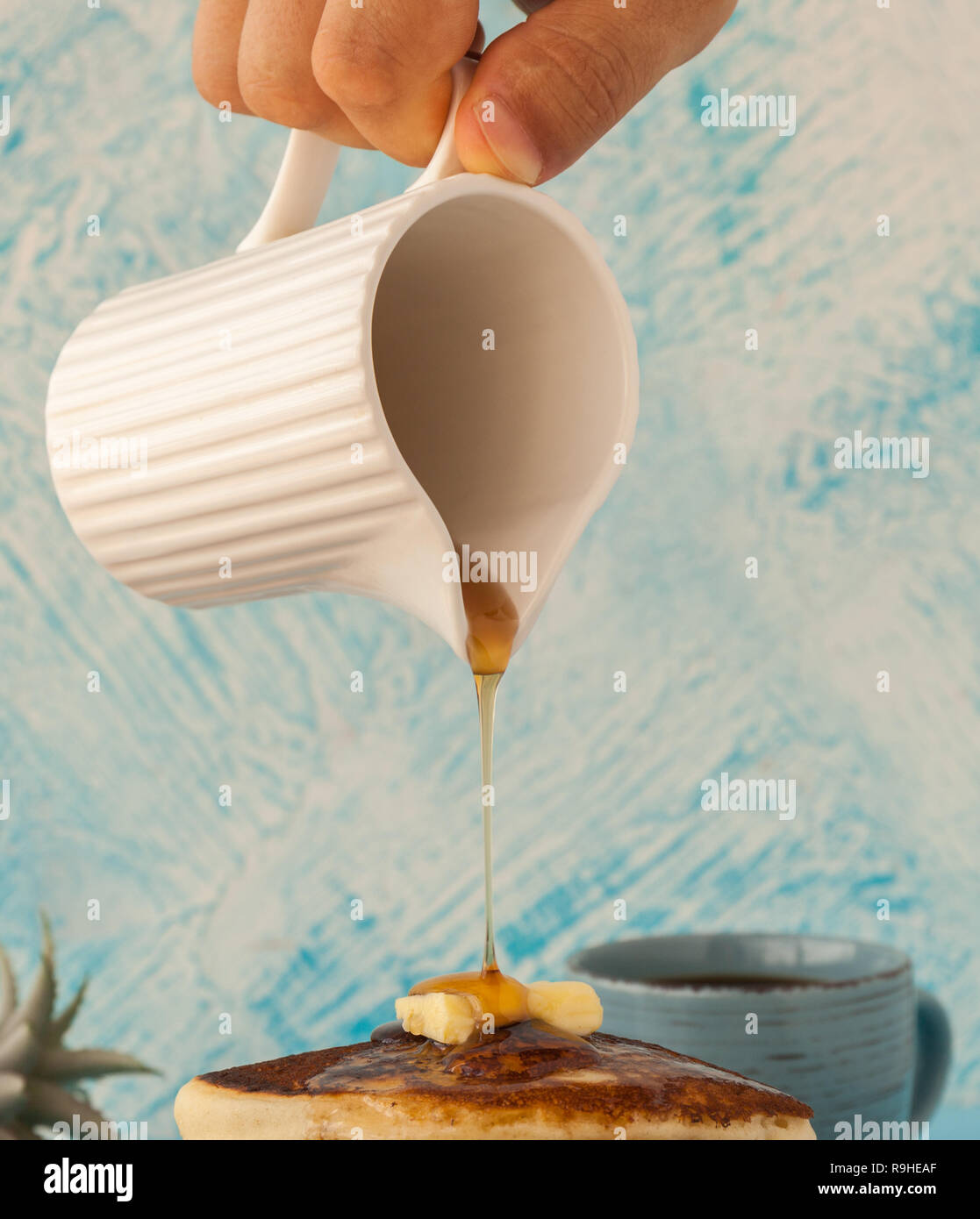 Pancakes stack pouring marple syrup. Little jug in a man's hand ...