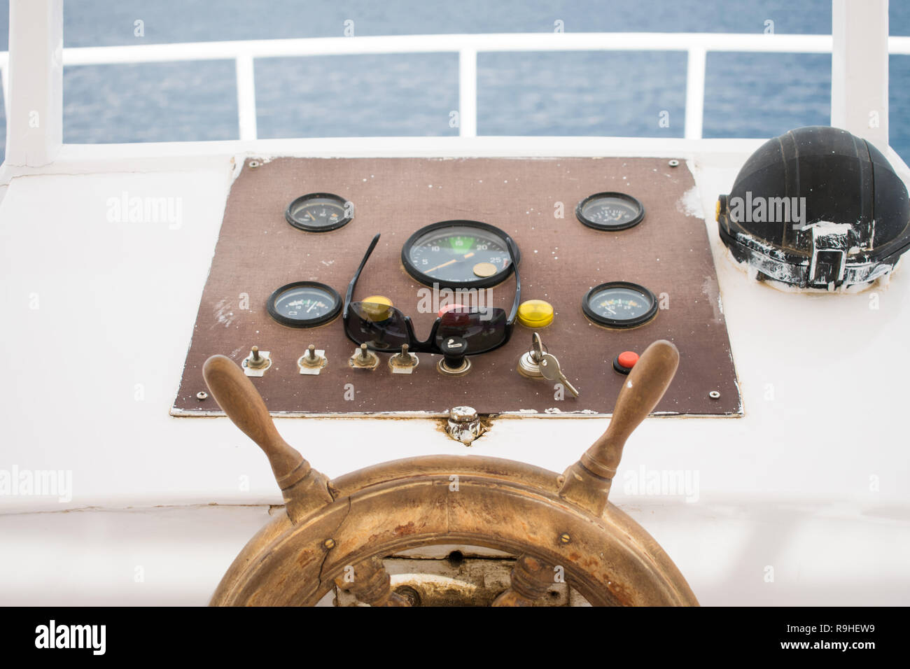 close-up wooden helm of a white yacht against the sea. captain's bridge ...