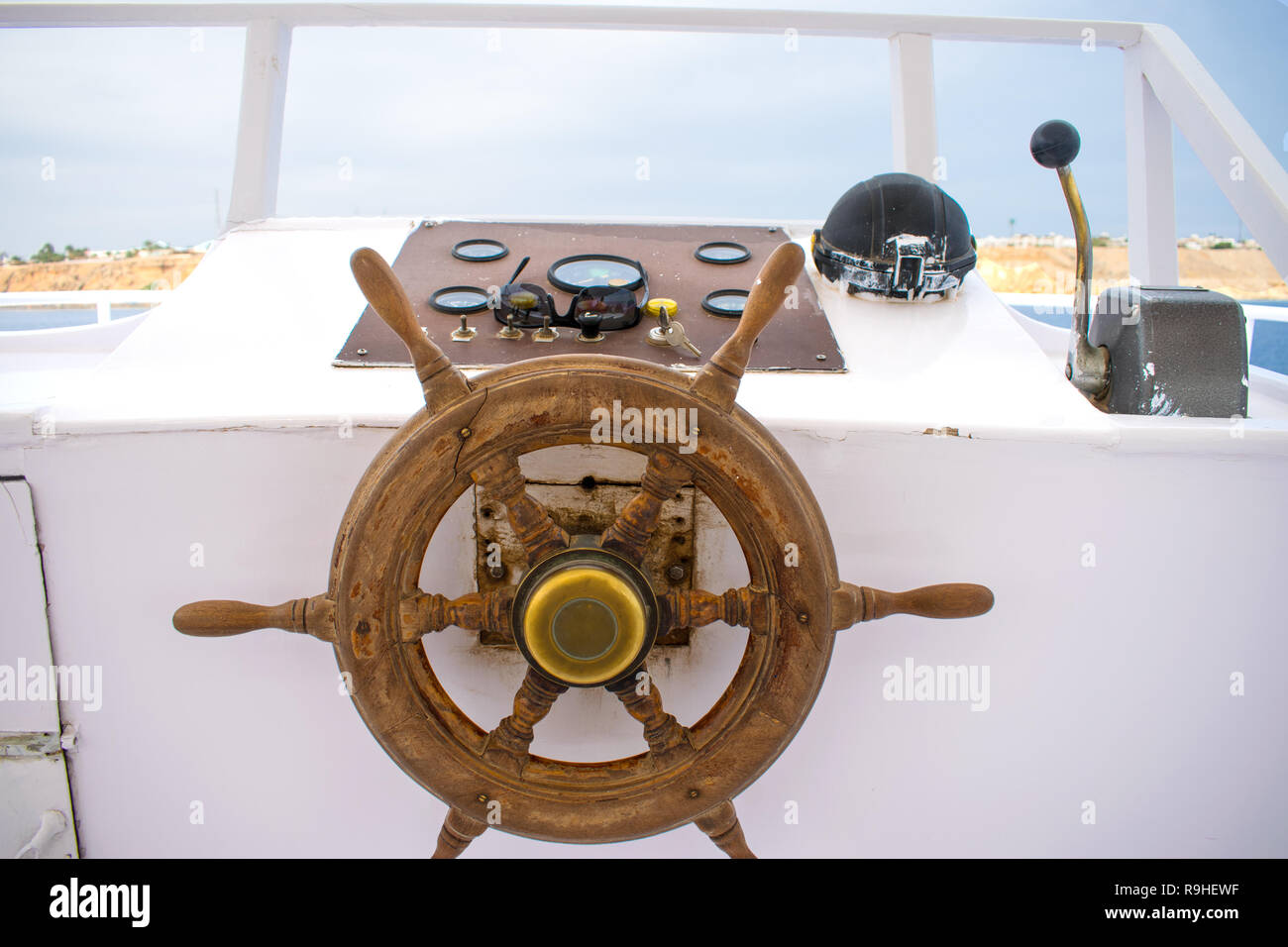 close-up wooden helm of a white yacht against the sea. captain's bridge ...