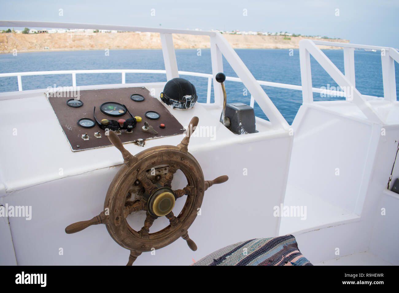 close-up wooden helm of a white yacht against the sea. captain's bridge ...