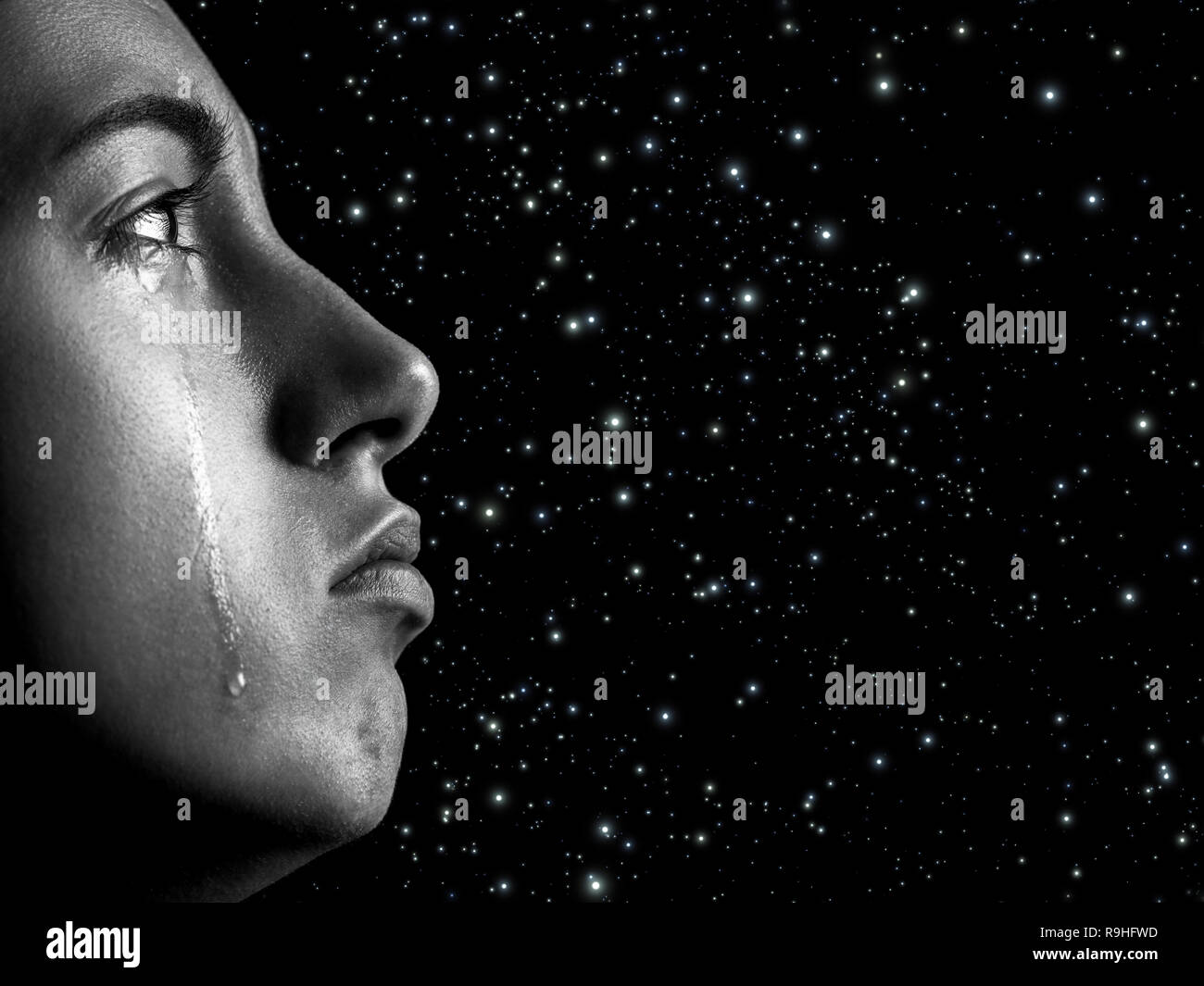 sad woman crying, looking up on stars background with copy space ...