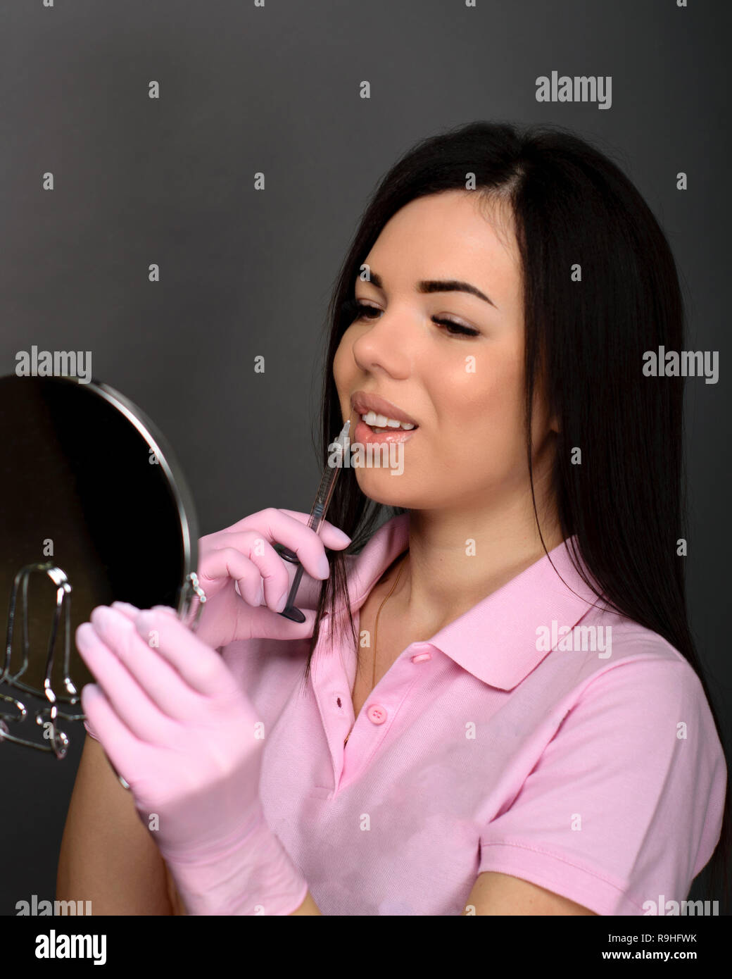 Beautician, cosmetologist on a gray background.A model with a syringe ...