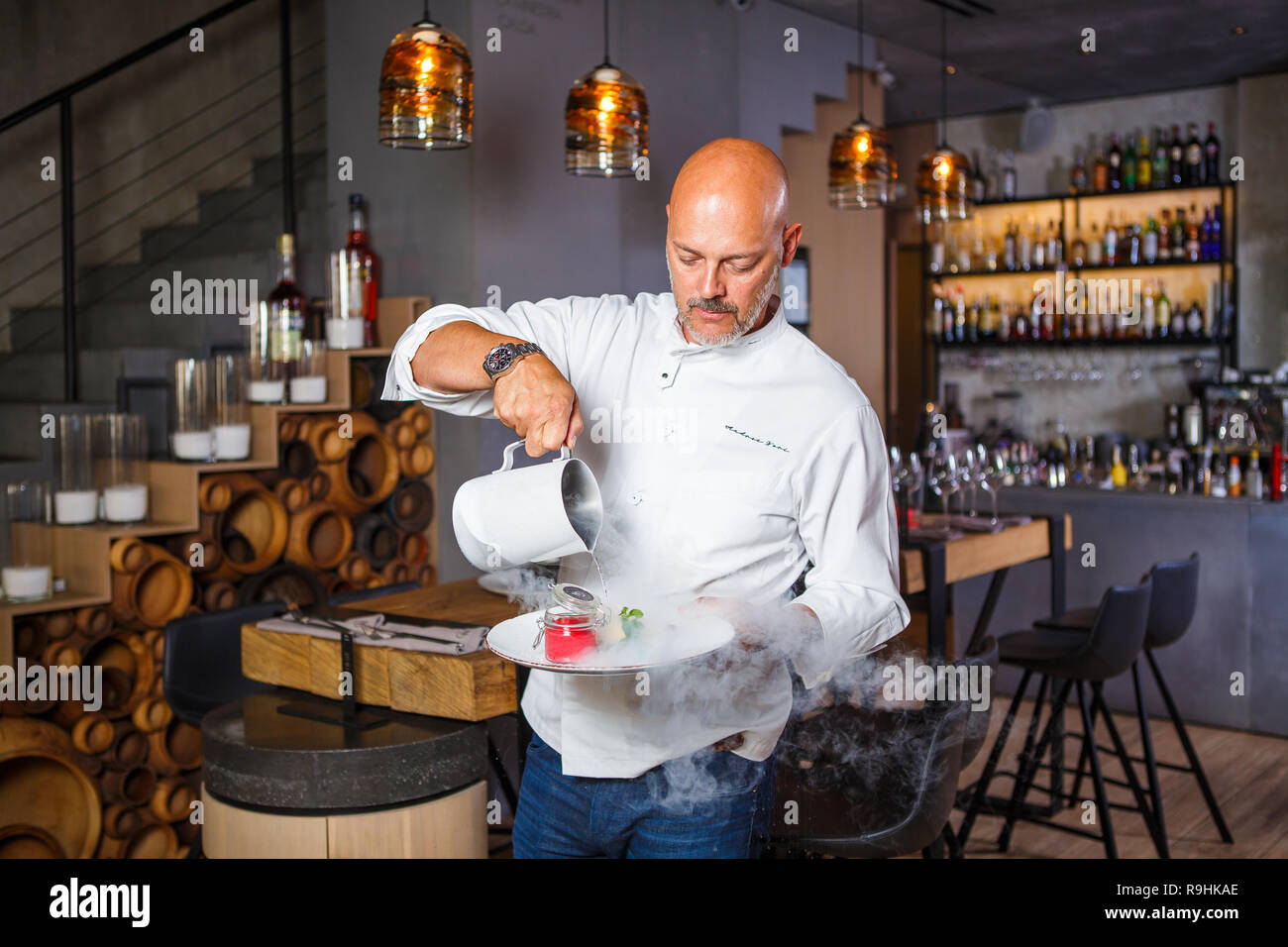 Handsome Italian man bald with a beard in white uniform chef in a ...