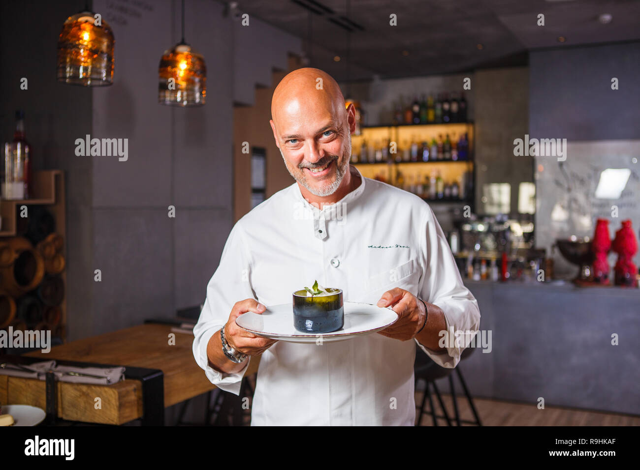 Handsome Italian man bald with a beard in white uniform chef in a ...