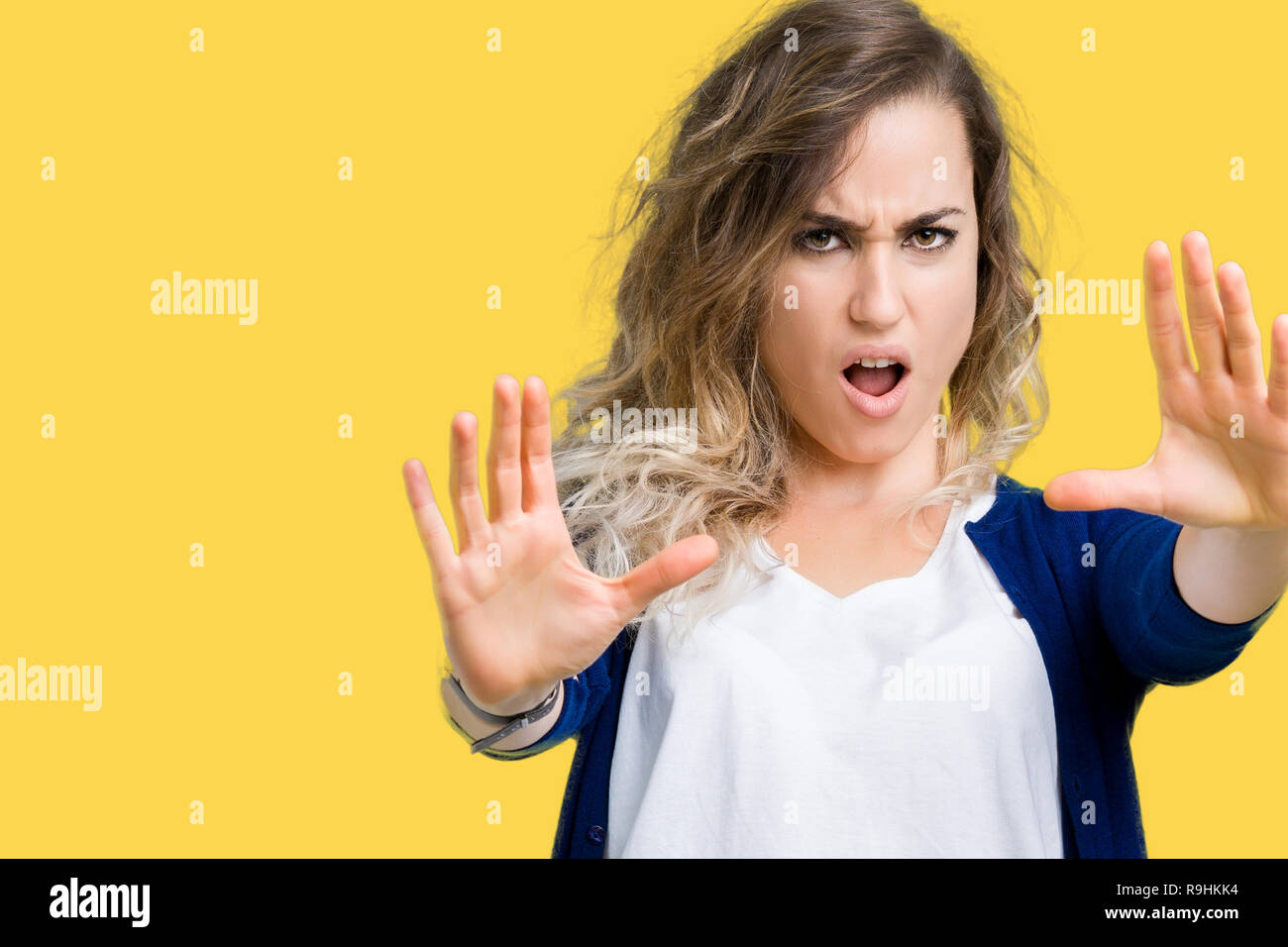 Beautiful young blonde woman over isolated background afraid and ...