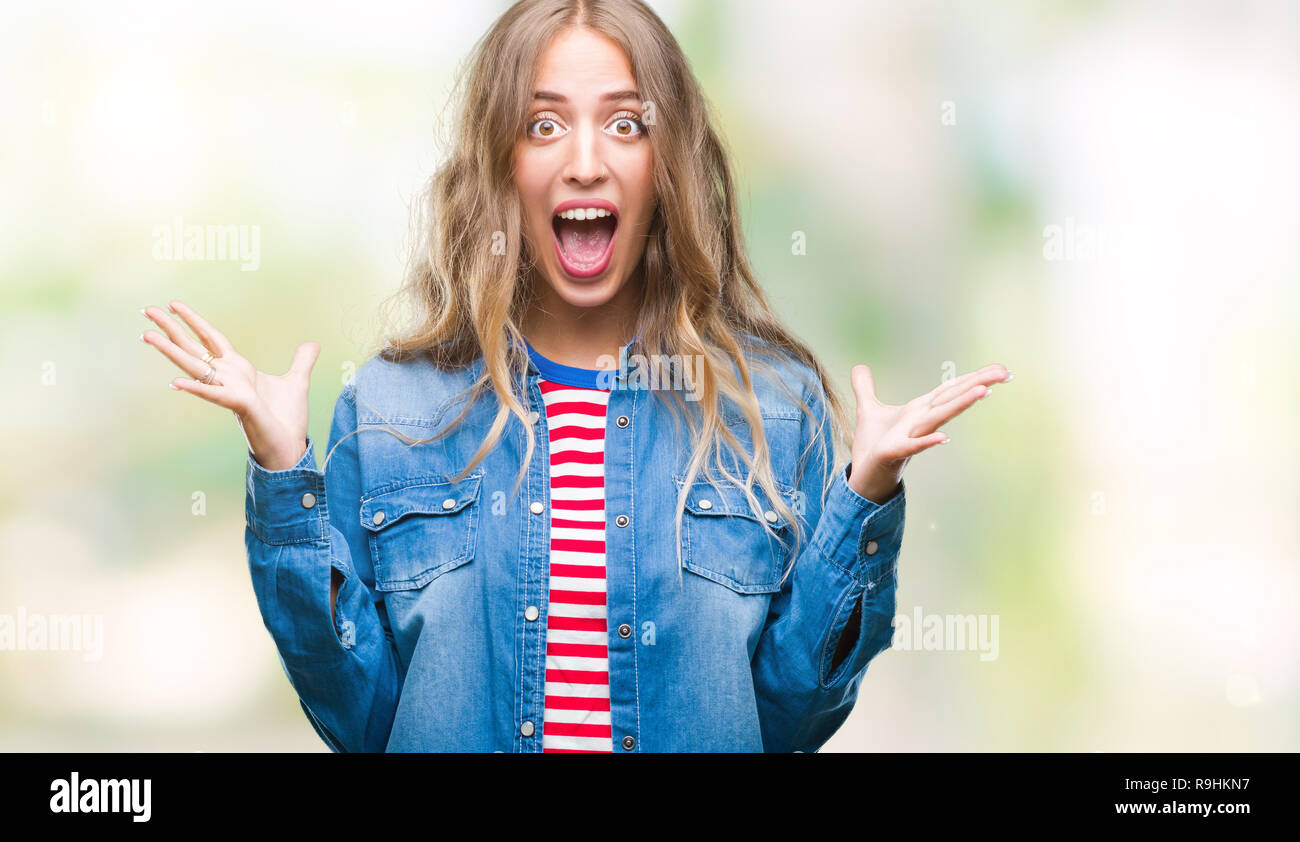 Beautiful young blonde woman over isolated background celebrating crazy ...