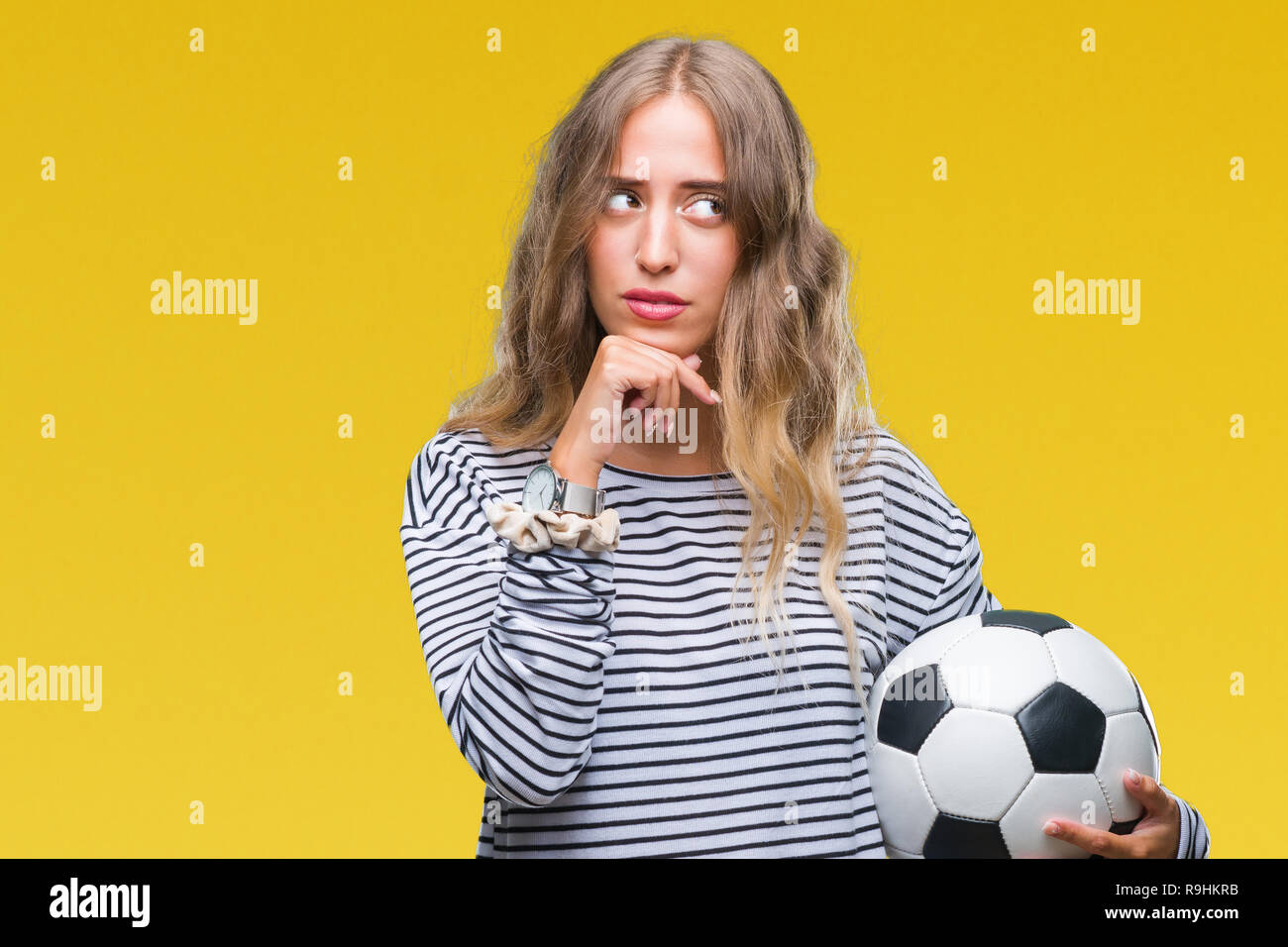 Beautiful young blonde woman holding soccer football ball over isolated ...