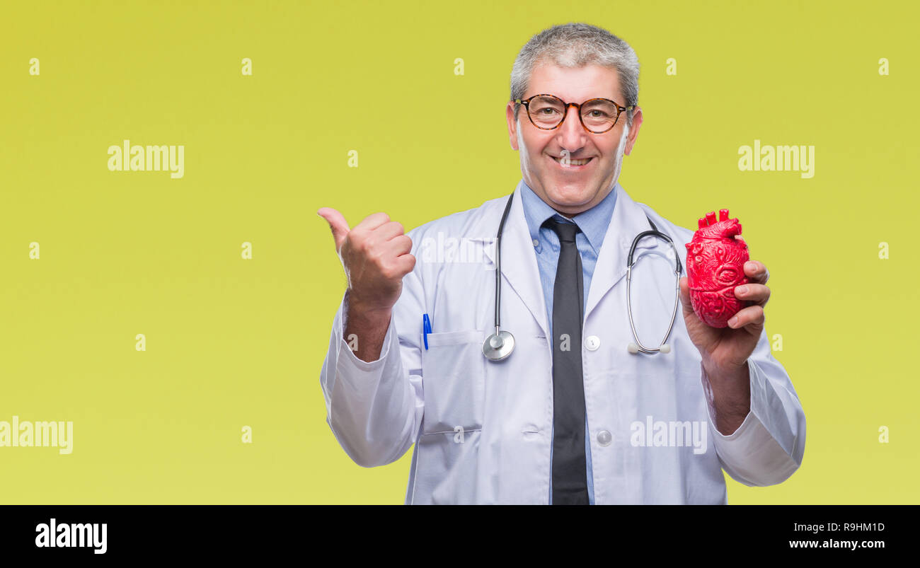Handsome senior cardiologist doctor man holding heart over isolated ...