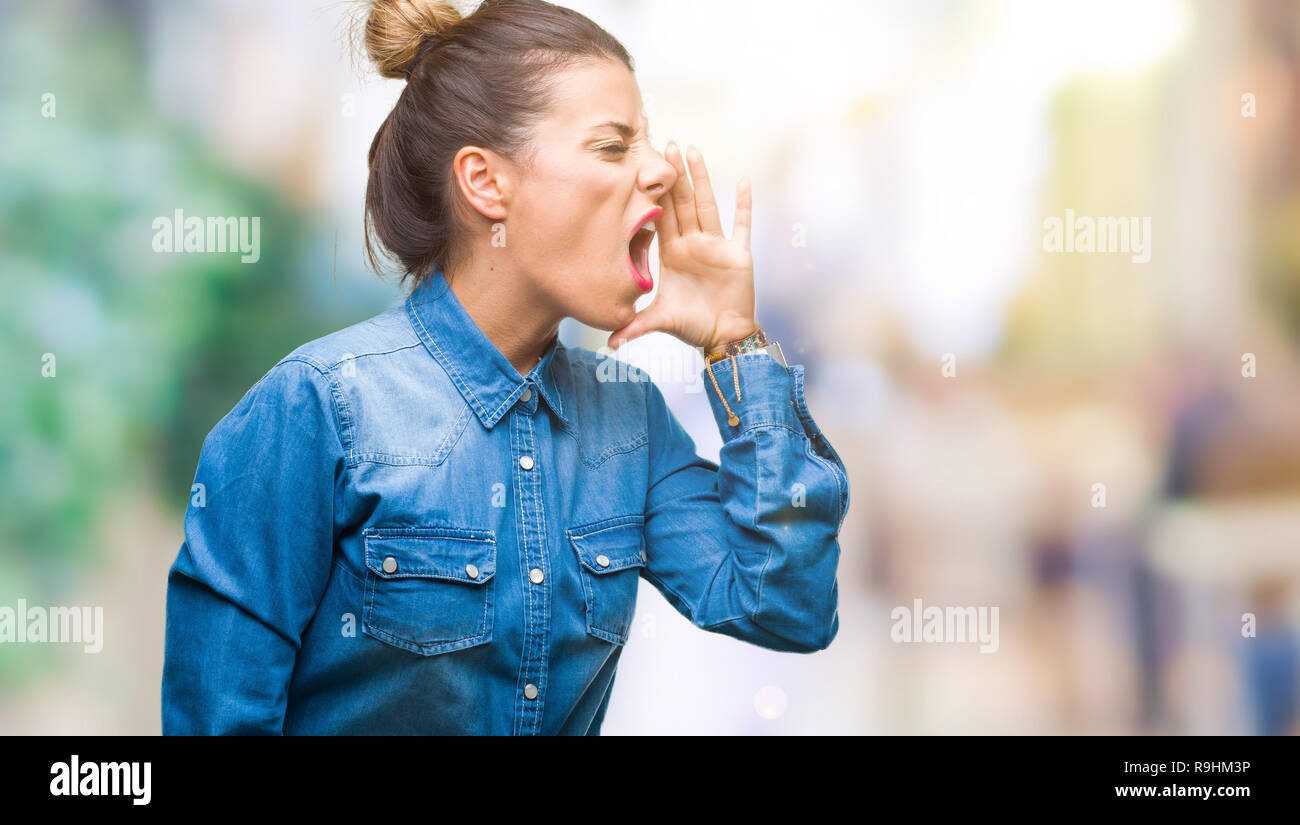 Young beautiful woman over isolated background shouting and screaming ...
