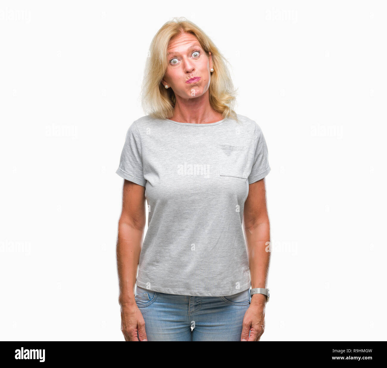 Middle age blonde woman over isolated background puffing cheeks with ...