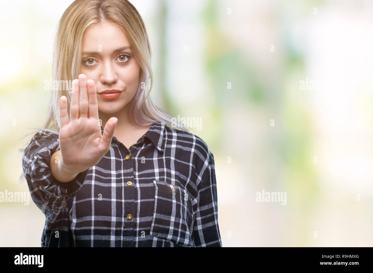 Young blonde woman over isolated background doing stop sing with palm ...