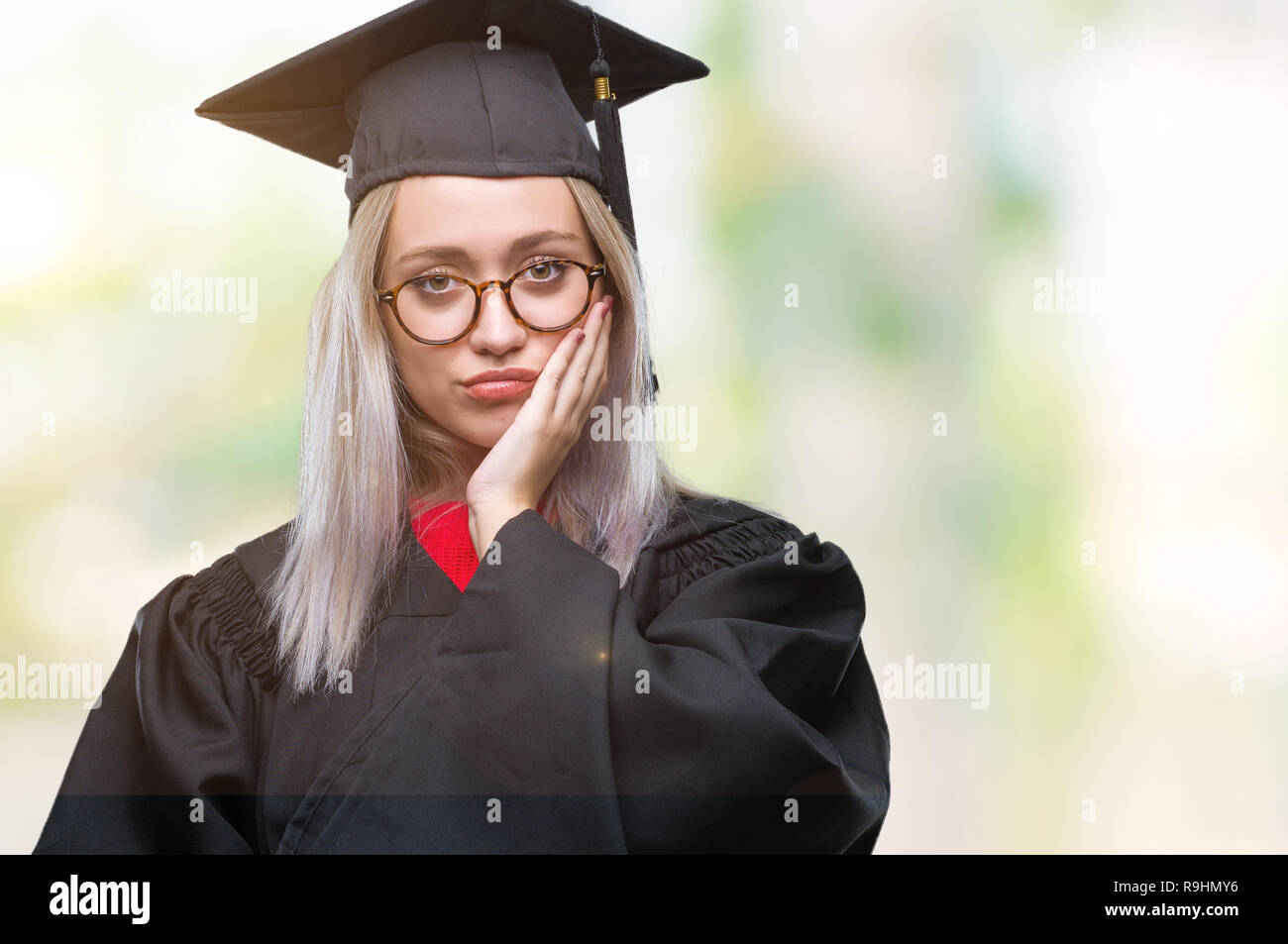 Young blonde woman wearing graduate uniform over isolated background ...