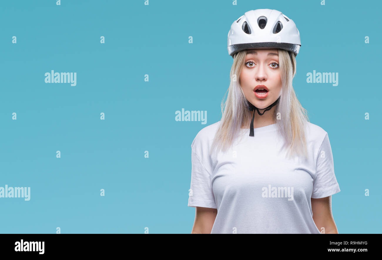Young blonde woman wearing cyclist security helmet over isolated ...
