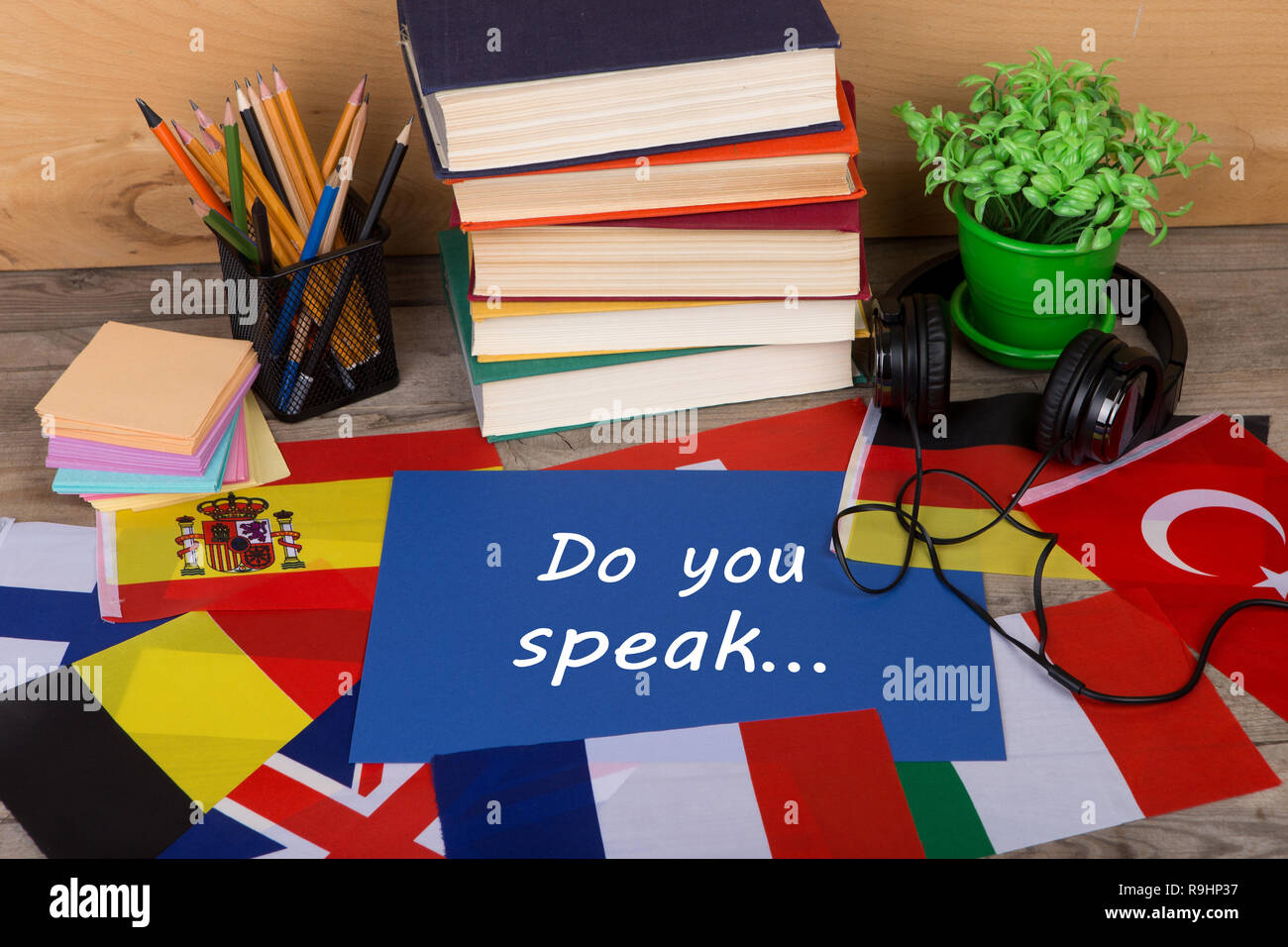 Learning languages concept - paper with text "Do you speak...", flags ...