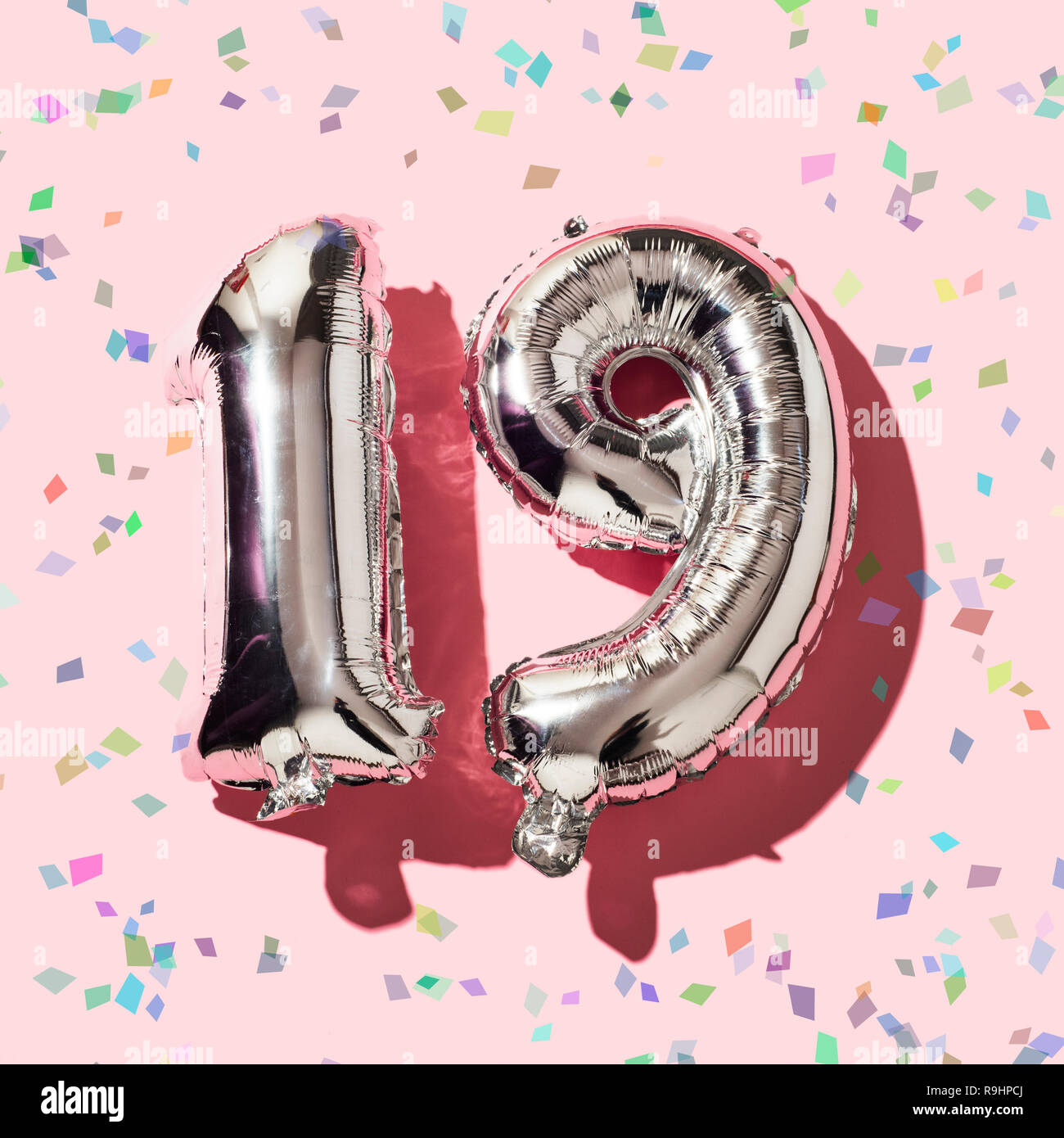 some confetti and some silvery number-shaped balloons forming the ...