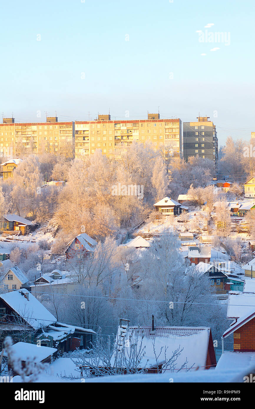 Apartment buildings in the city in the winter and snow covered trees ...
