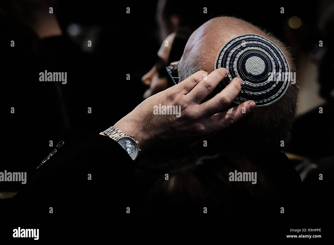A Jewish man holds his hand to his head bearing a traditional Jewish ...