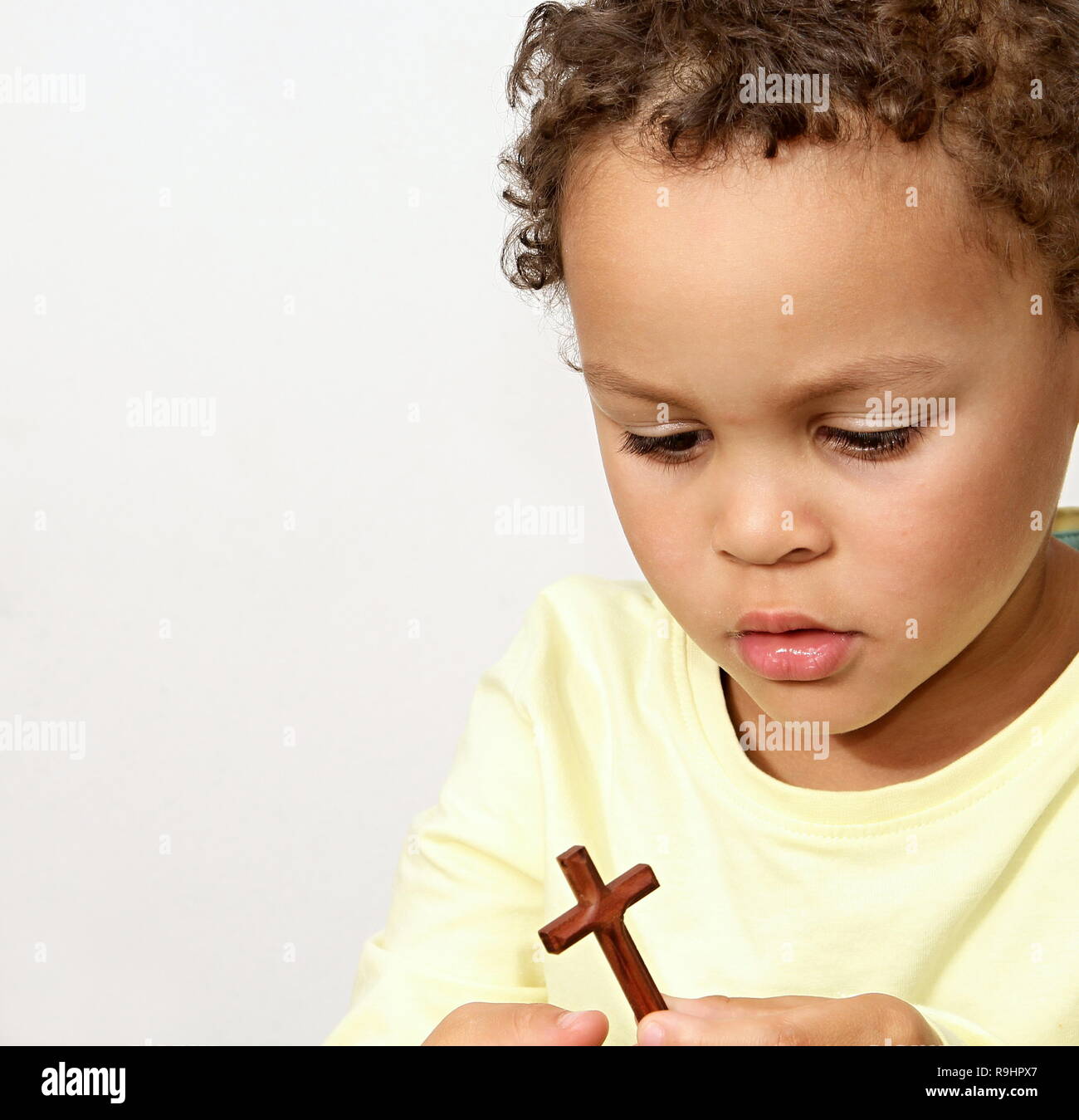 boy praying kissing the cross on white background with people stock ...