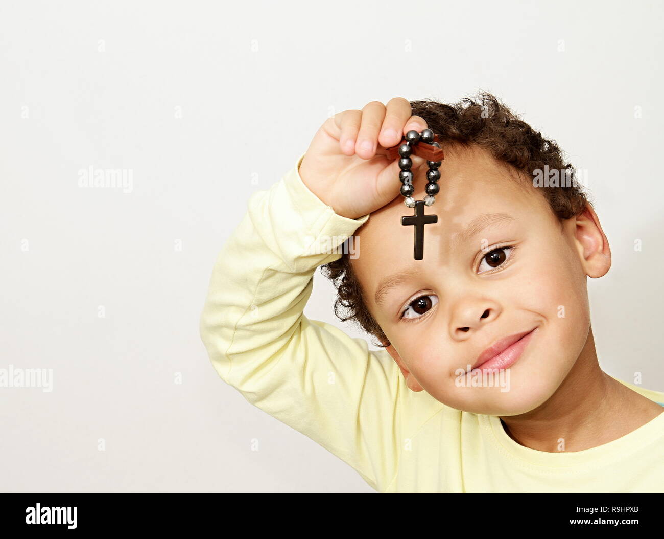 boy praying kissing the cross on white background with people stock ...