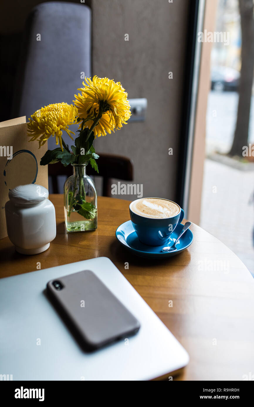 Coffee shop desk table with smartphone, laptop computer and cup of ...
