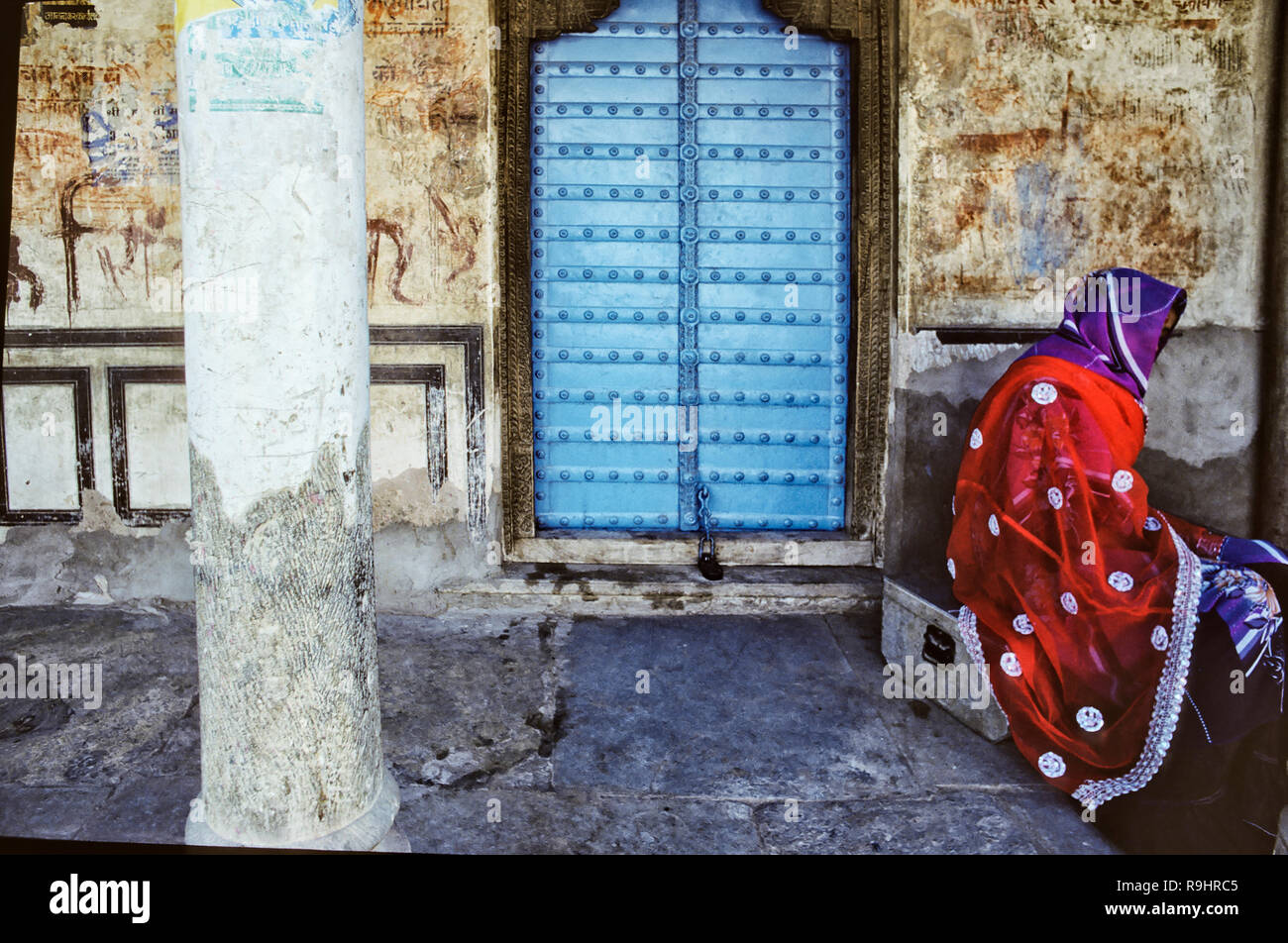 woman in sari in front of a haveli with a beautiful iron gate and ...