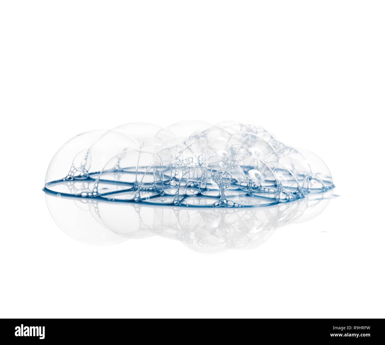 Soap bubbles with a blue tint on a flat surface with a reflection Stock ...