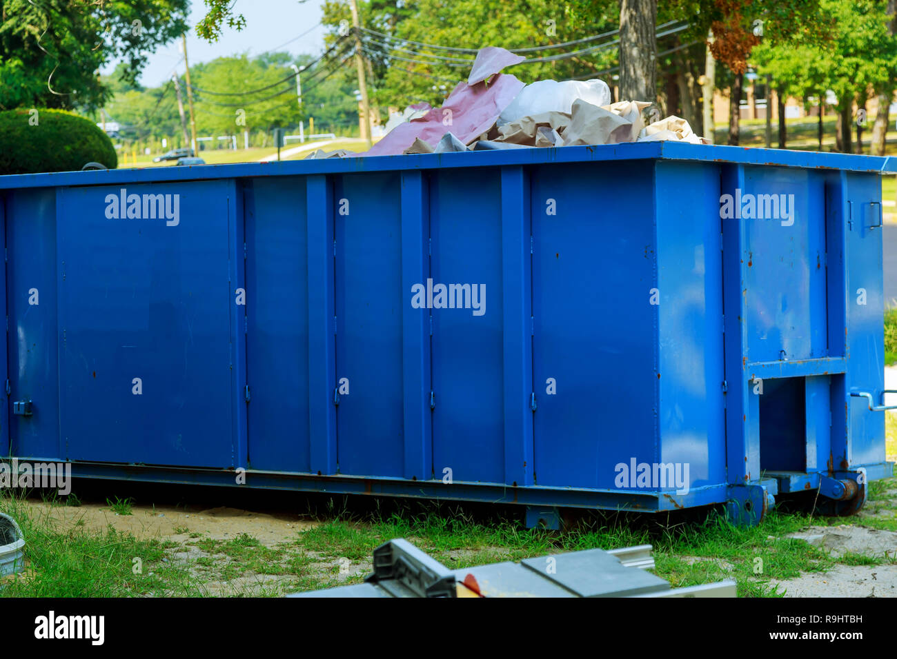 Blue metal waste container with building debris Stock Photo - Alamy