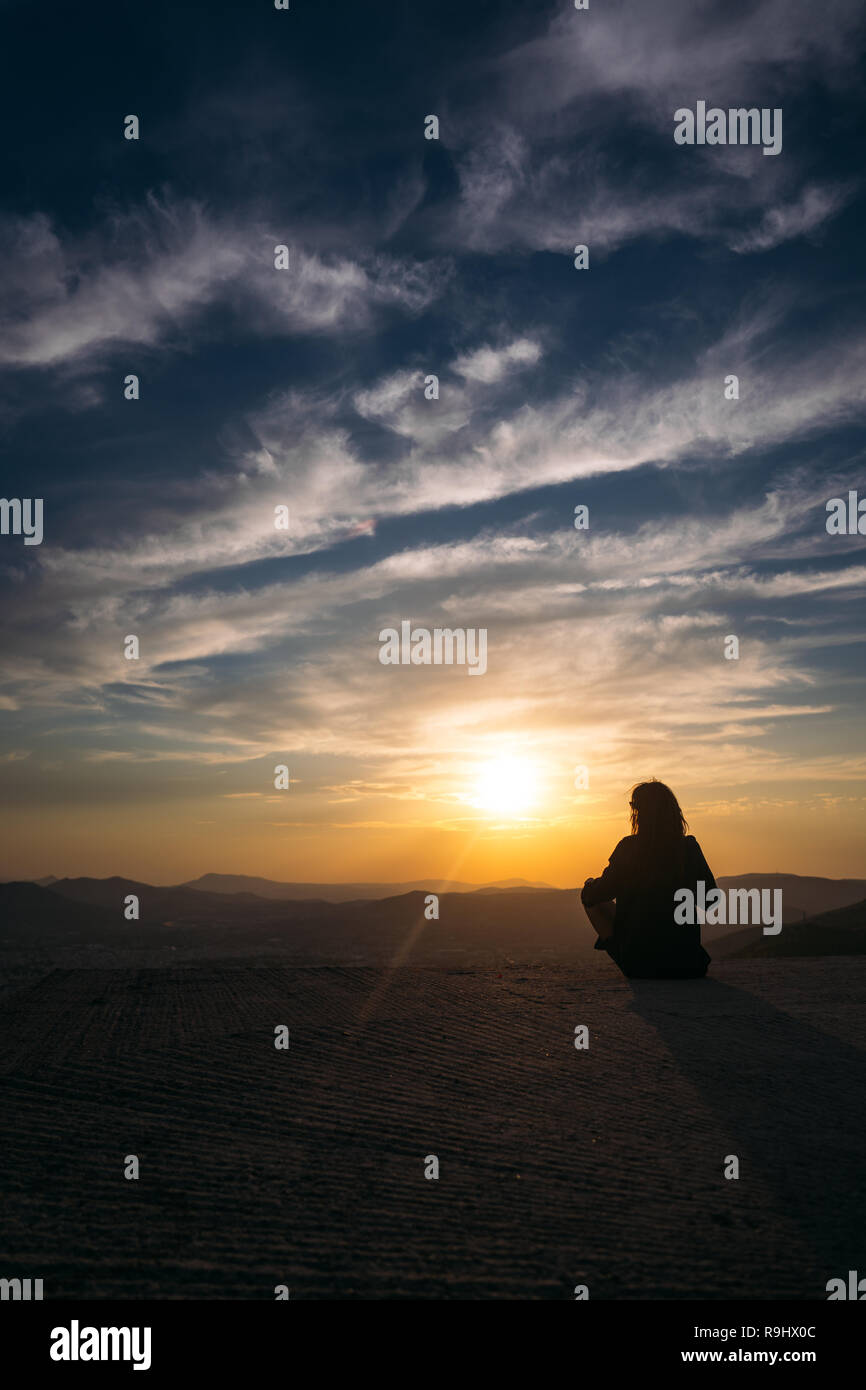 A young girl stands on the observation deck and admires the beautiful ...
