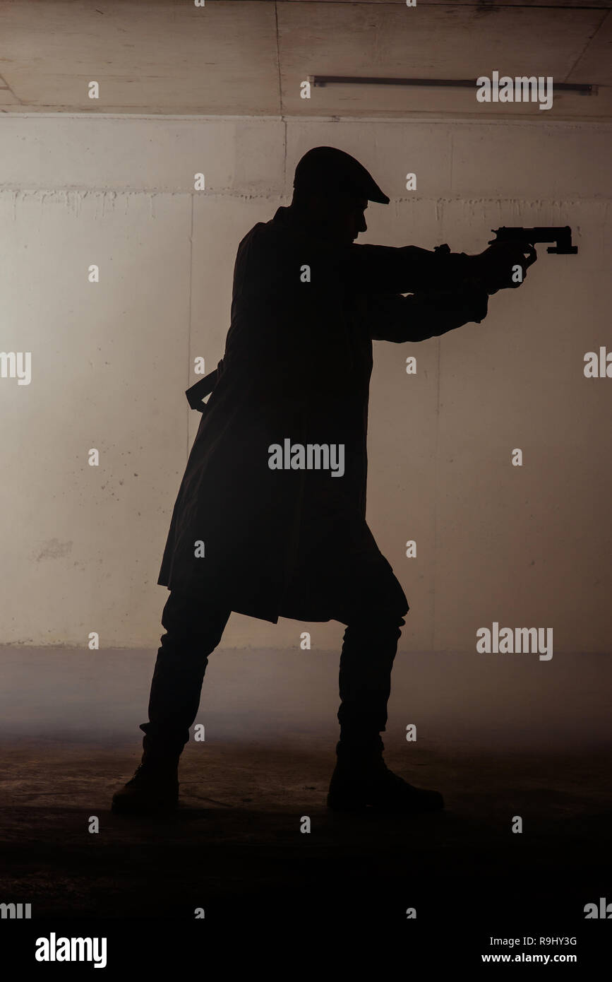 Shape of a man who is holding revolver in his hands Stock Photo - Alamy