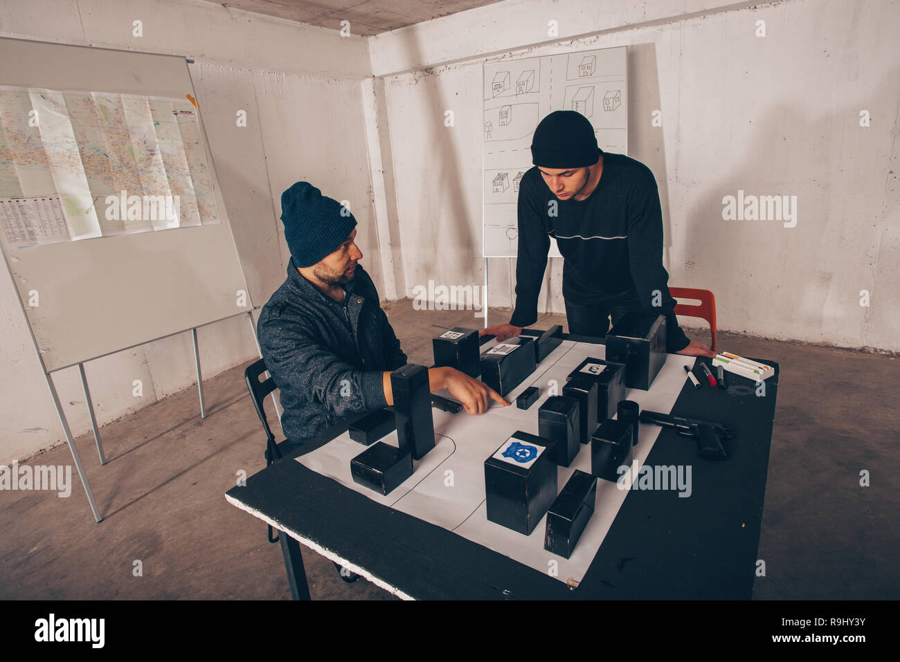 Two men sitting in a room and planning a robbery Stock Photo - Alamy