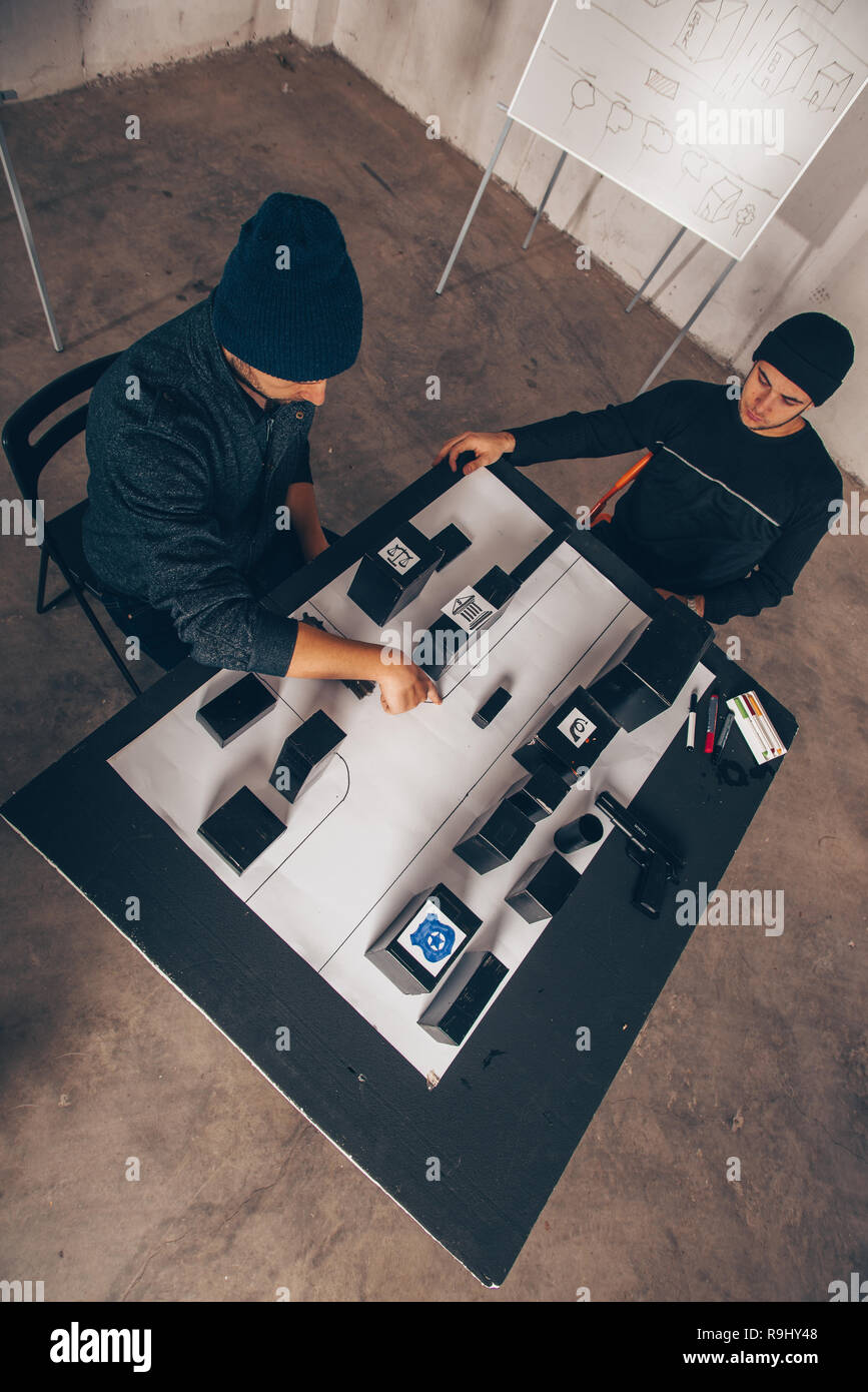 Two young thiefs are sitting in a room and planning a heist Stock Photo ...
