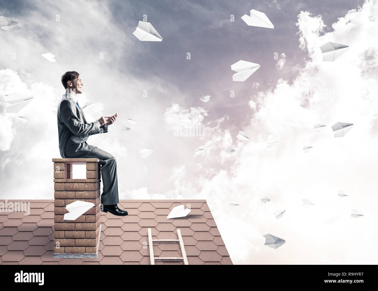 Man on brick roof send message with smartphone and paper planes Stock ...