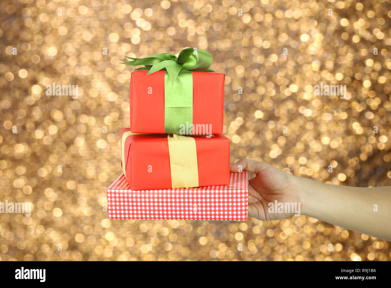 Red Gift Box on hand for Christmas concept with gold blur bokeh ...