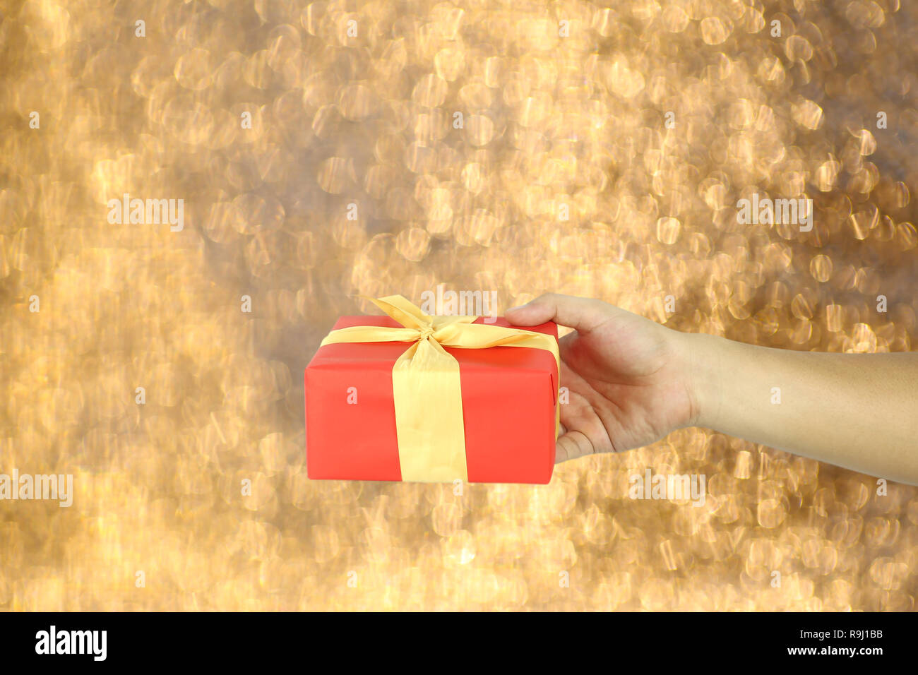 Red Gift Box on hand for Christmas concept with gold blur bokeh ...