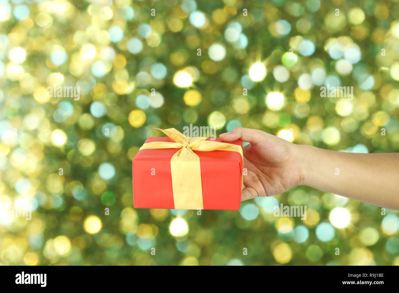 Red Gift Box on hand for Christmas concept with green blur bokeh ...