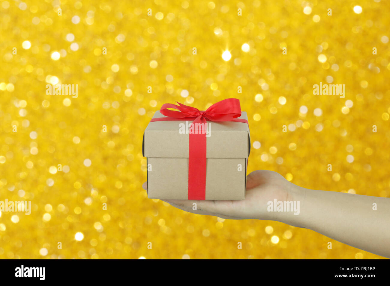 Brown Gift Box on hand for Christmas concept with yellow blur bokeh ...