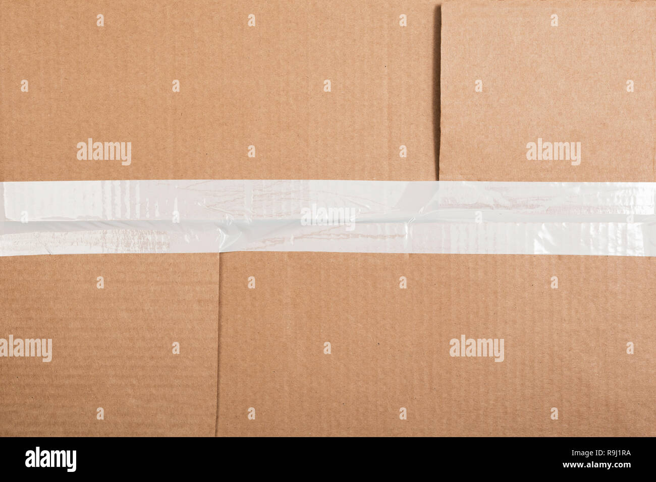 Corrugated cardboard with a white sticky tape. Cardboard box background ...